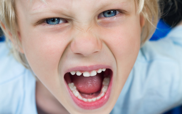 Close-up portrait of a very angry screaming boy - Beating Trauma
